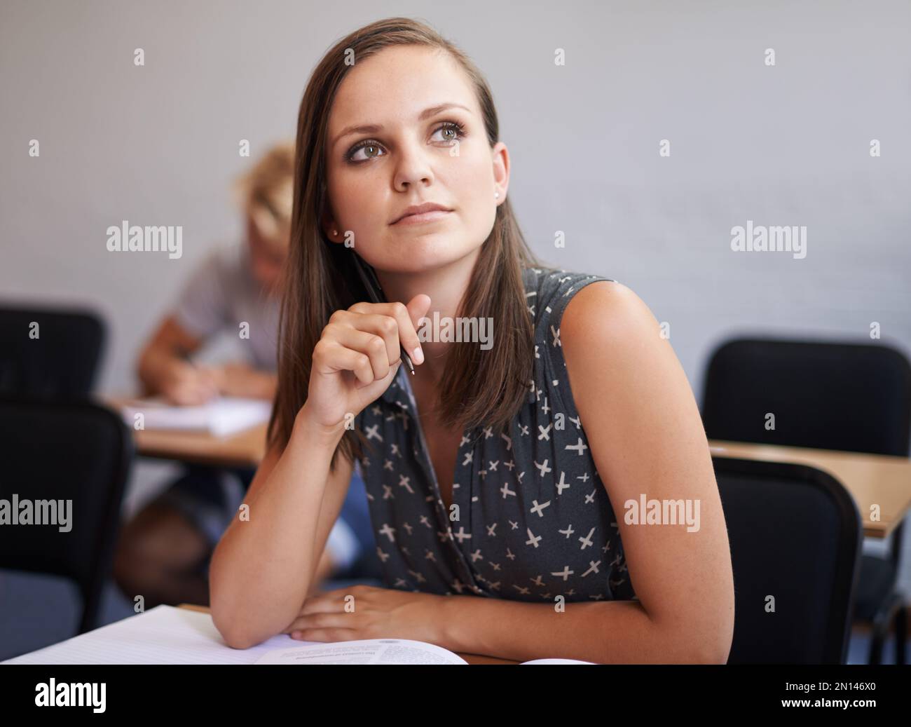 Dreaming big. An attractive young varsity student sitting in a ...