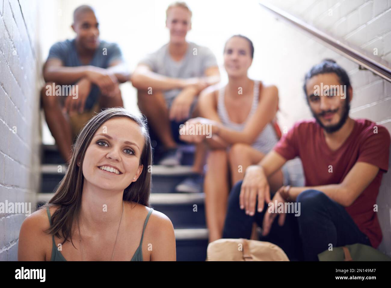 Relaxing before class. university students sitting on the steps of a ...