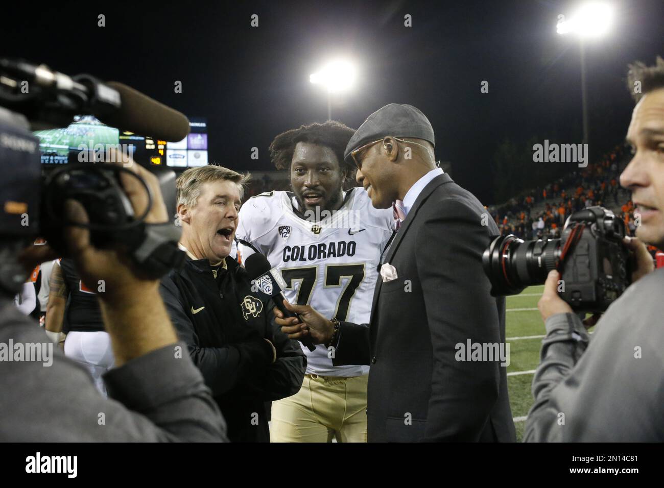 Colorado head coach Mike MacIntyre, left, is photobombed by left tackle ...