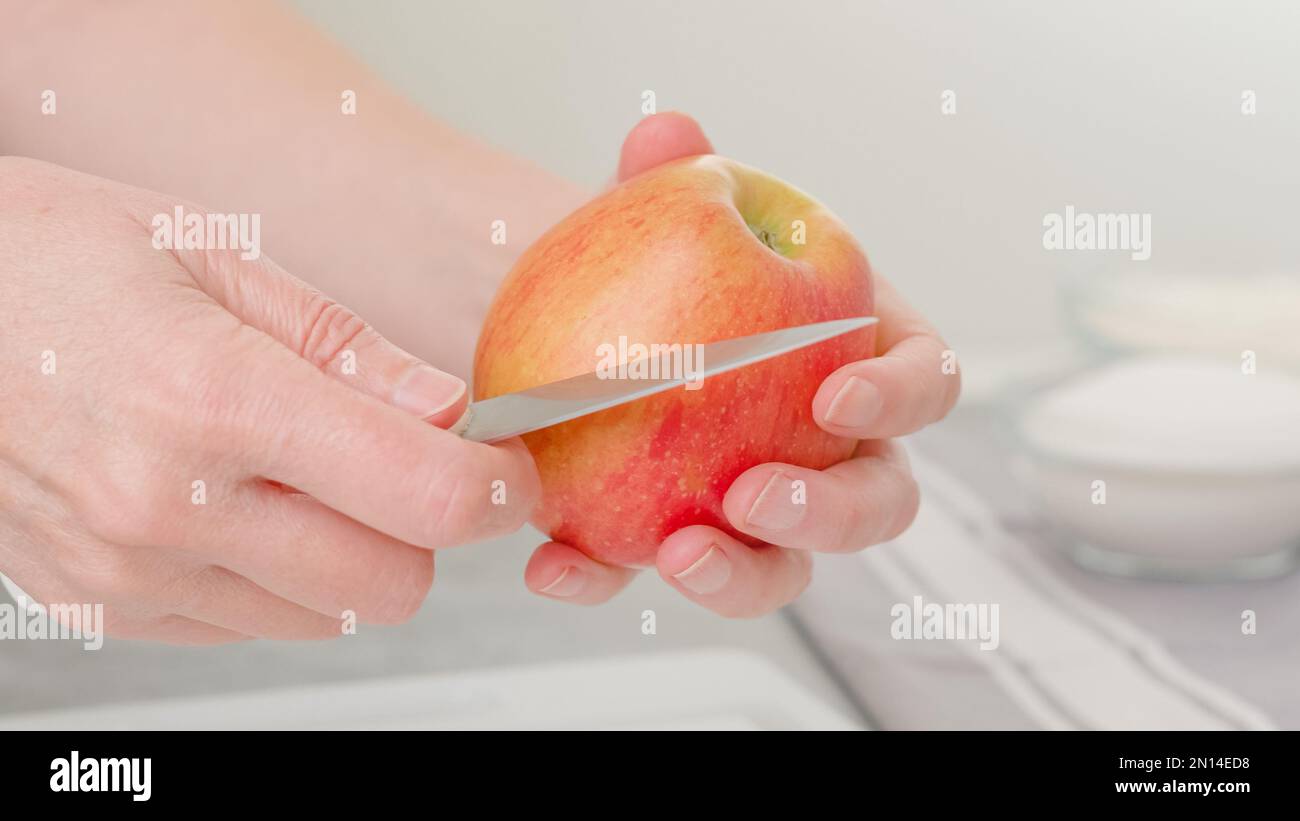 Woman hands holding red apple and a knife, close-up view, apple pie ...