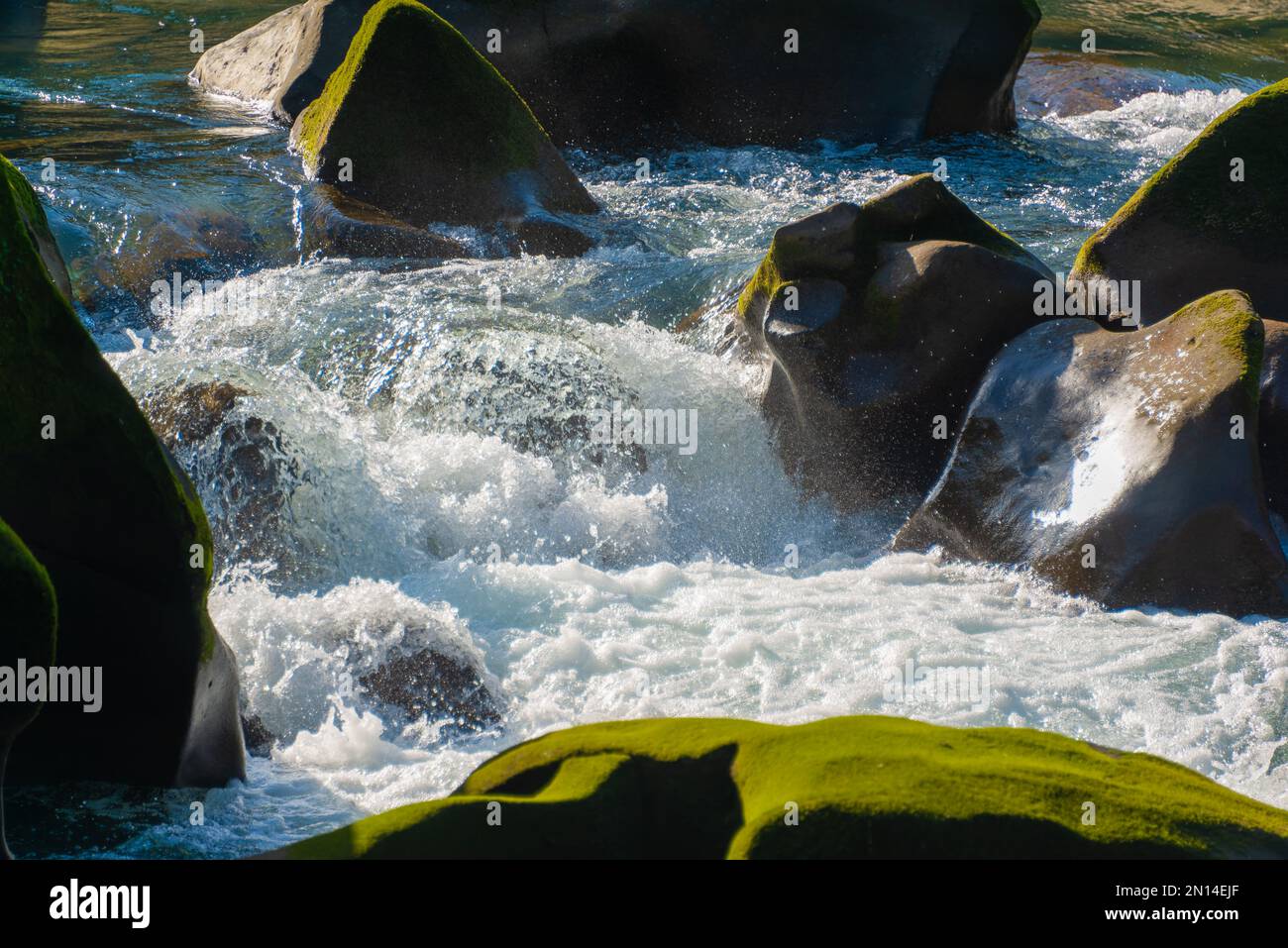 White turbulent streams. Oddly shaped rocks with some moss growing on ...