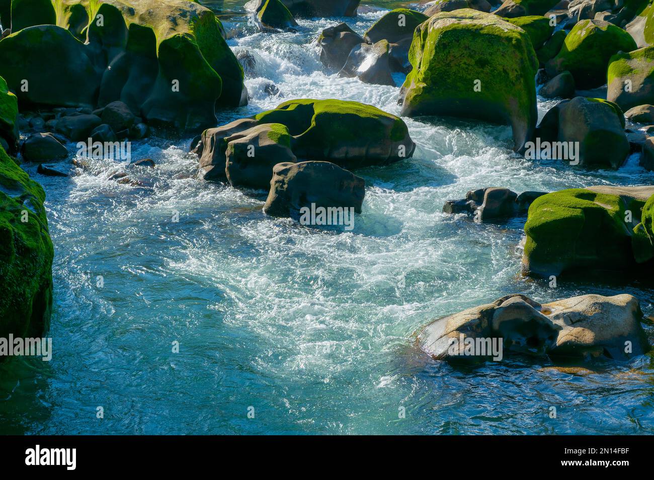 White turbulent streams. Oddly shaped rocks with some moss growing on ...