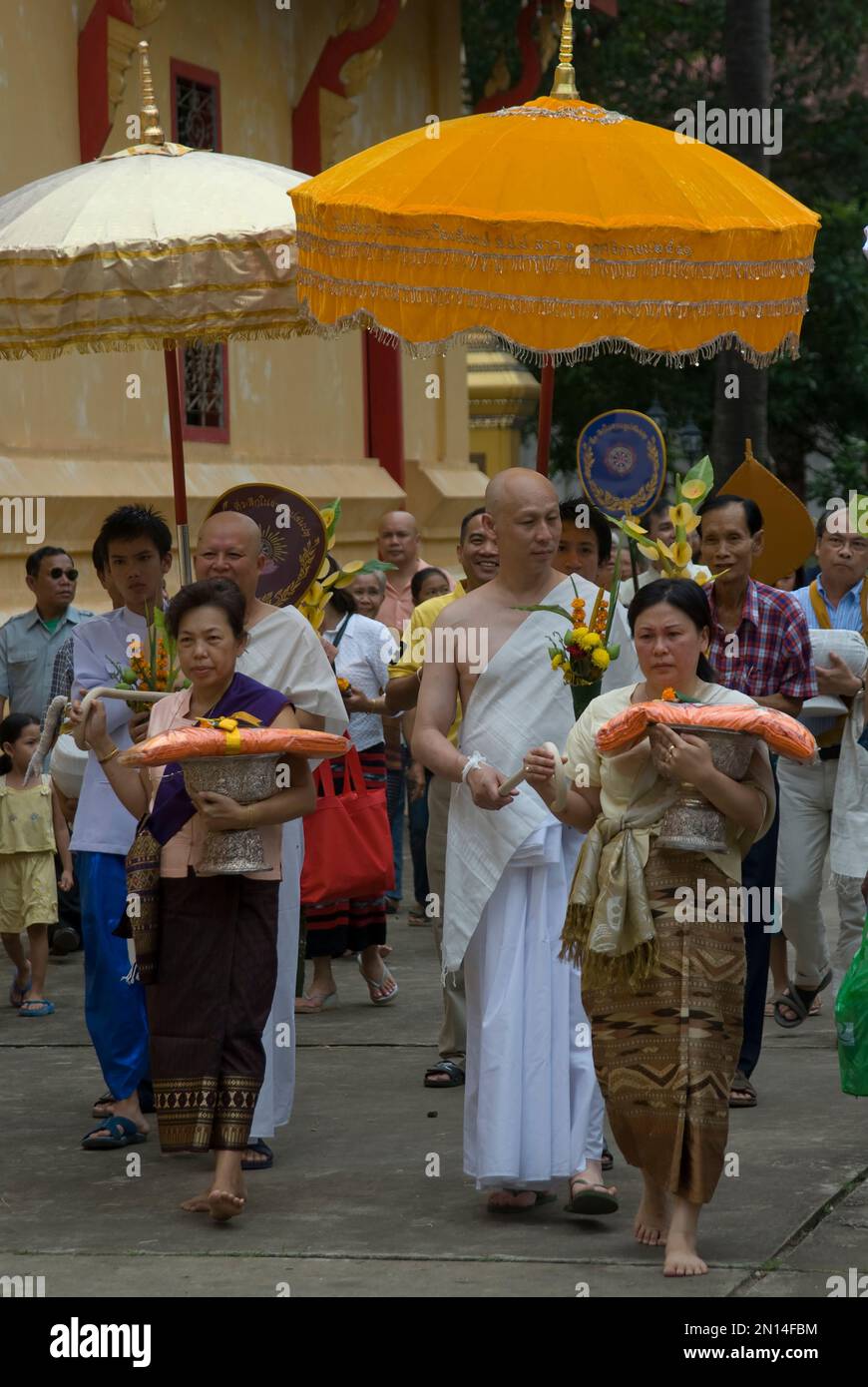 Novice monks in ceremony walking around temple, with family & friends ...