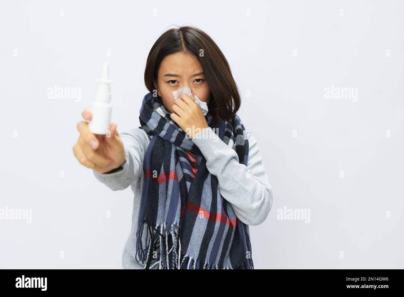 Asian woman flu cold with stuffy nose holds allergy nasal spray with ...