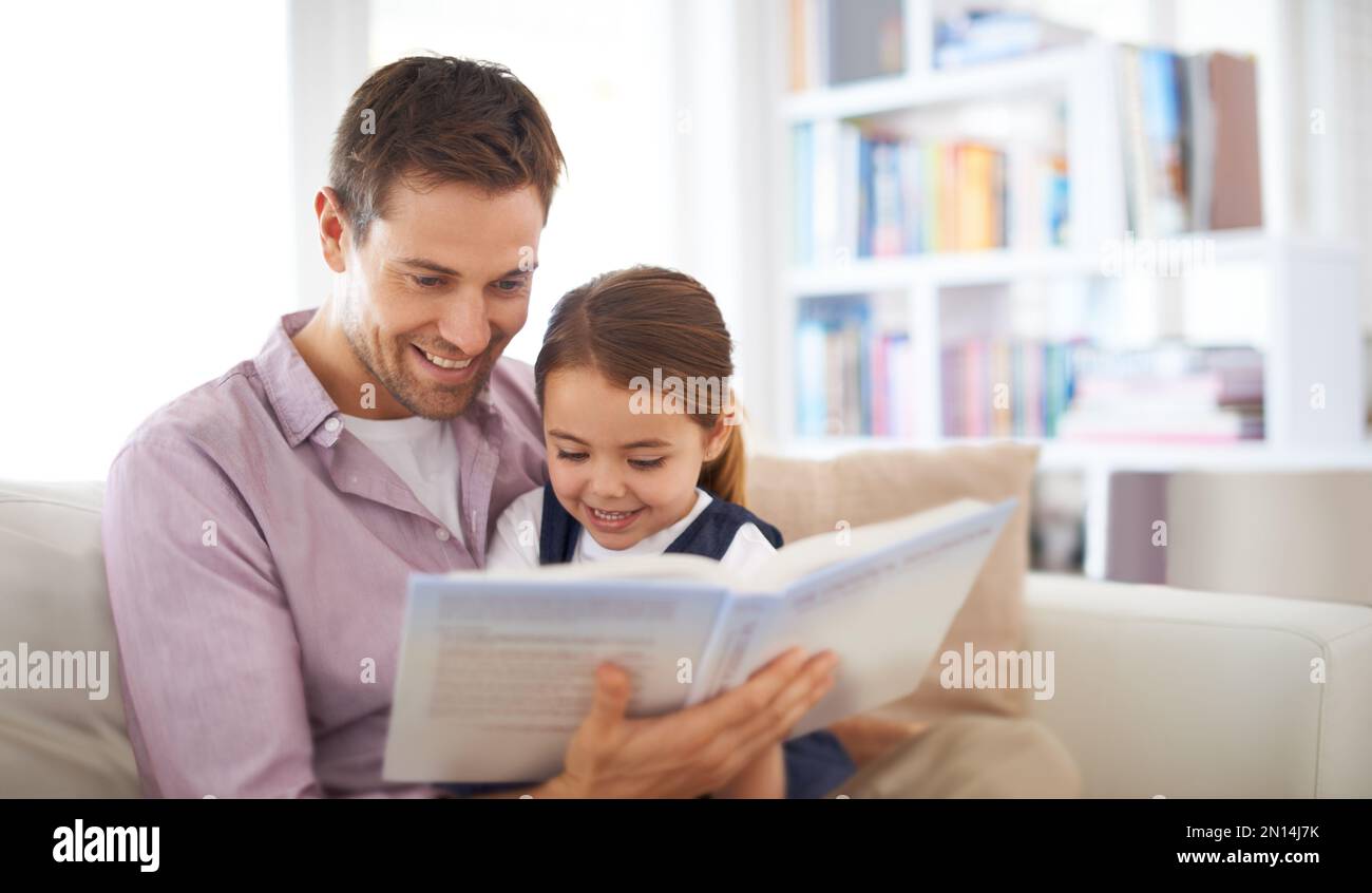 Bonding over a book. a young father reading a book with his daughter ...