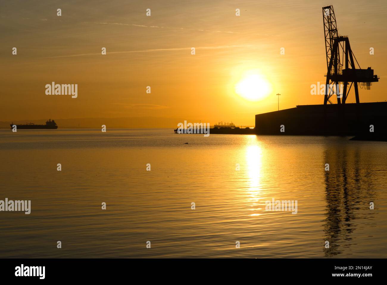 Large cargo ship to the left and container crane to the right during ...