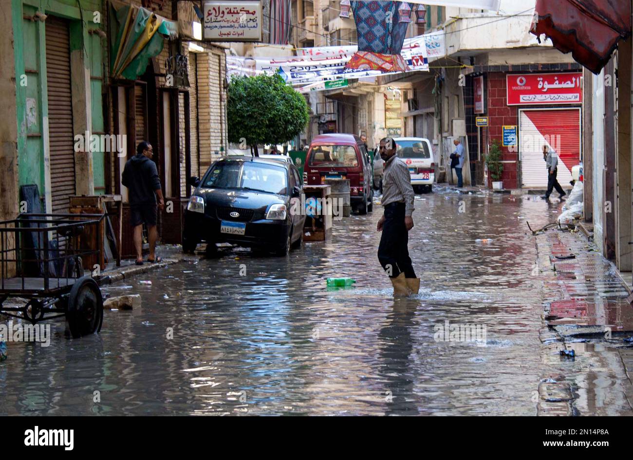 Egyptians walk across a flooded street after a heavy rainfall in the ...