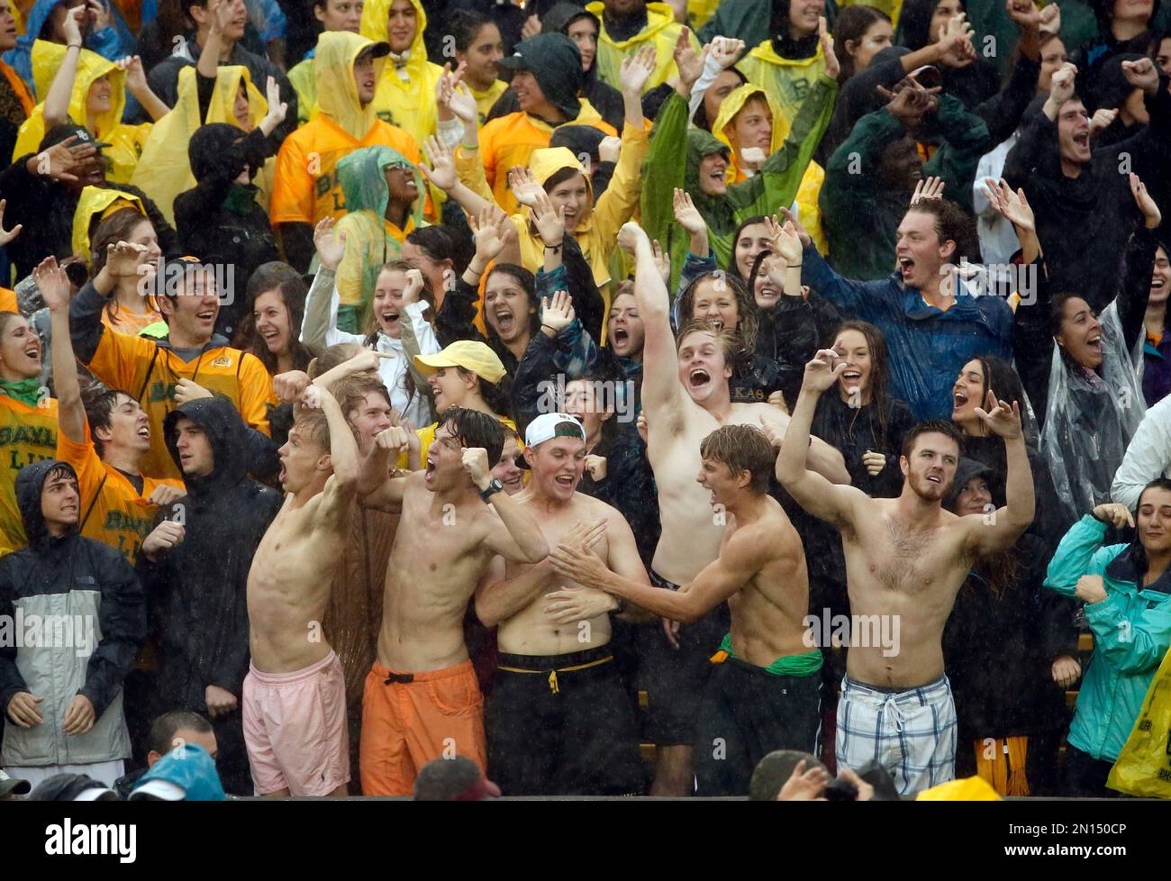 Rain soaked fans cheer on their team in the first half of an NCAA ...