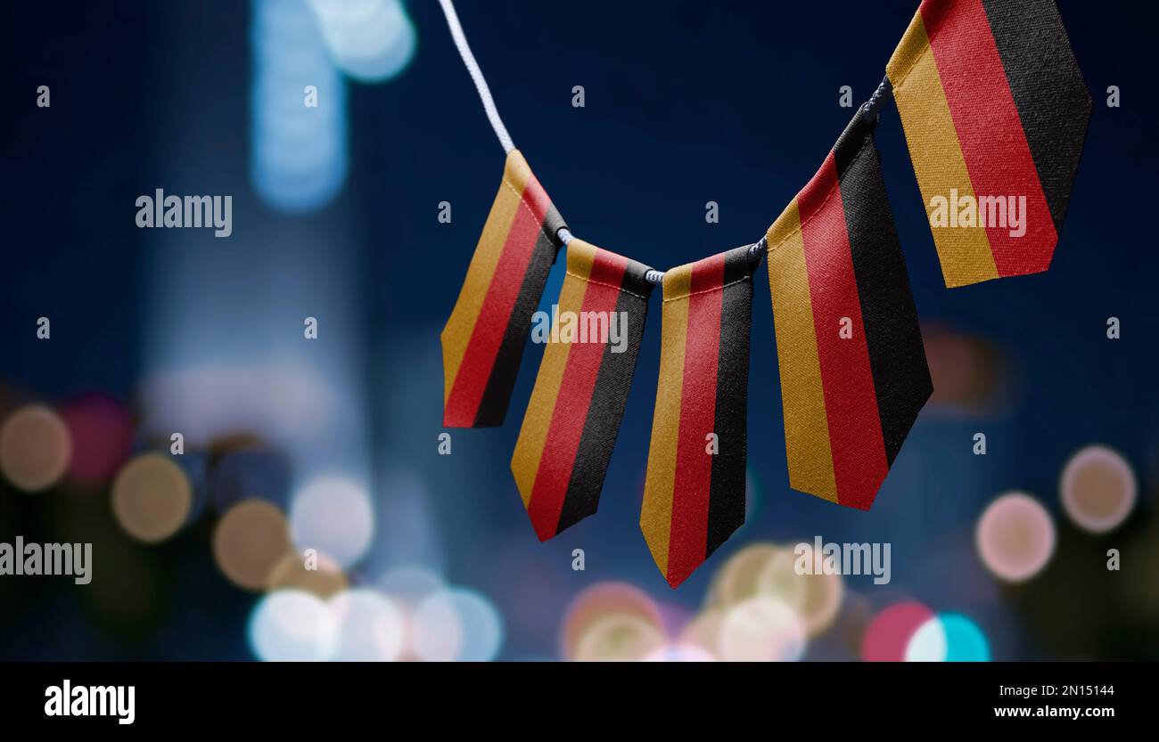 A garland of Germany national flags on an abstract blurred background ...