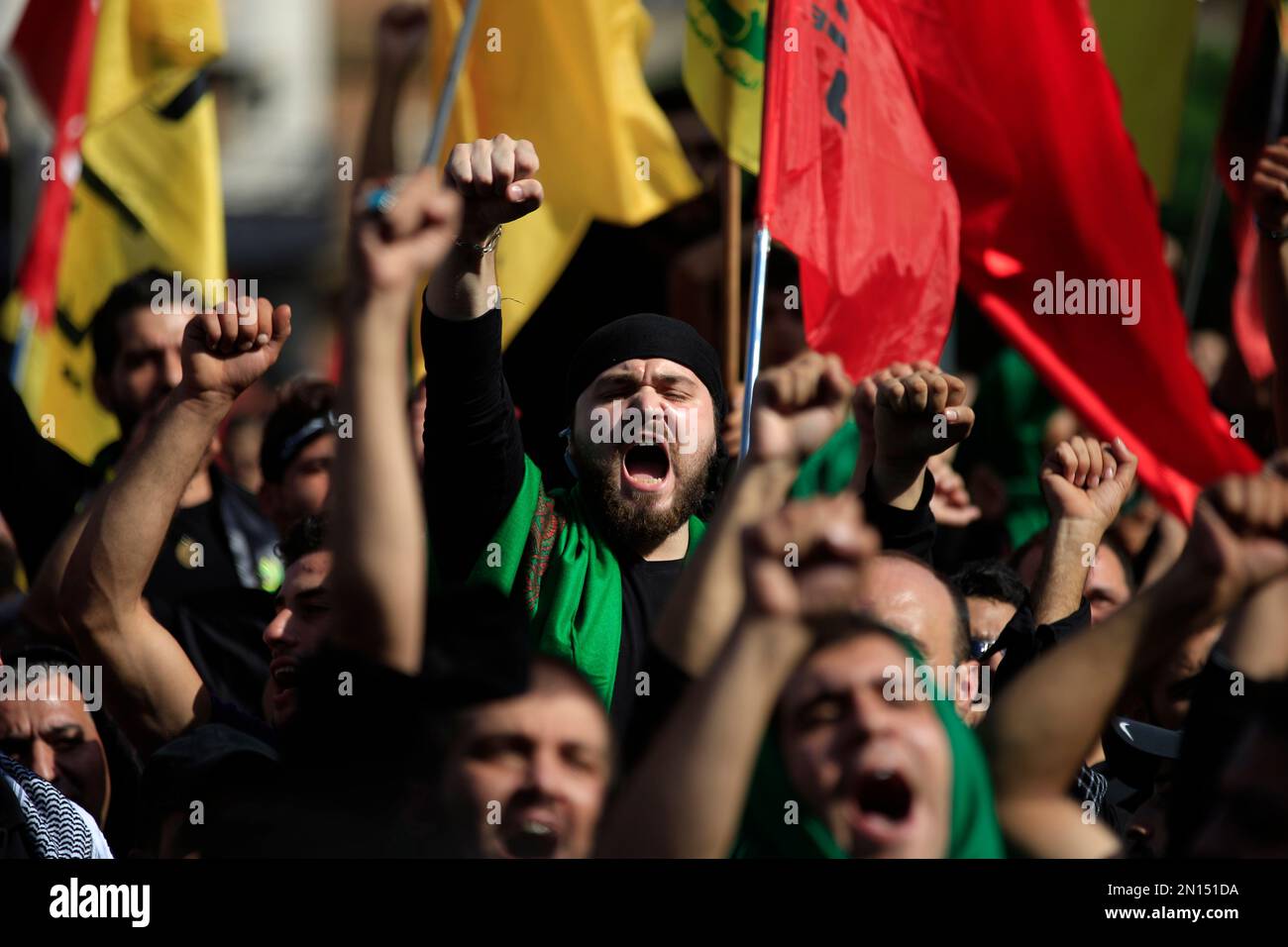 Hezbollah supporters raise their hands as their leader, Sheik Hassan ...