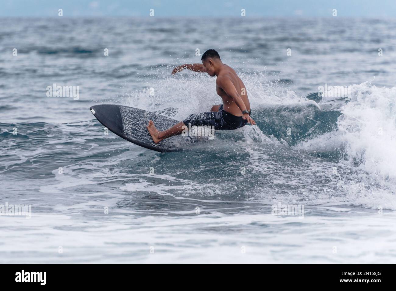 Man surfing on the wave with a surf board in Keramas Beach, Bali ...
