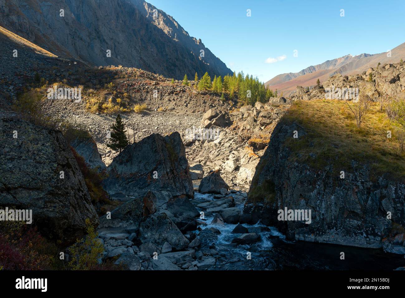 The Shavla River flows in the shade among large stones against the ...