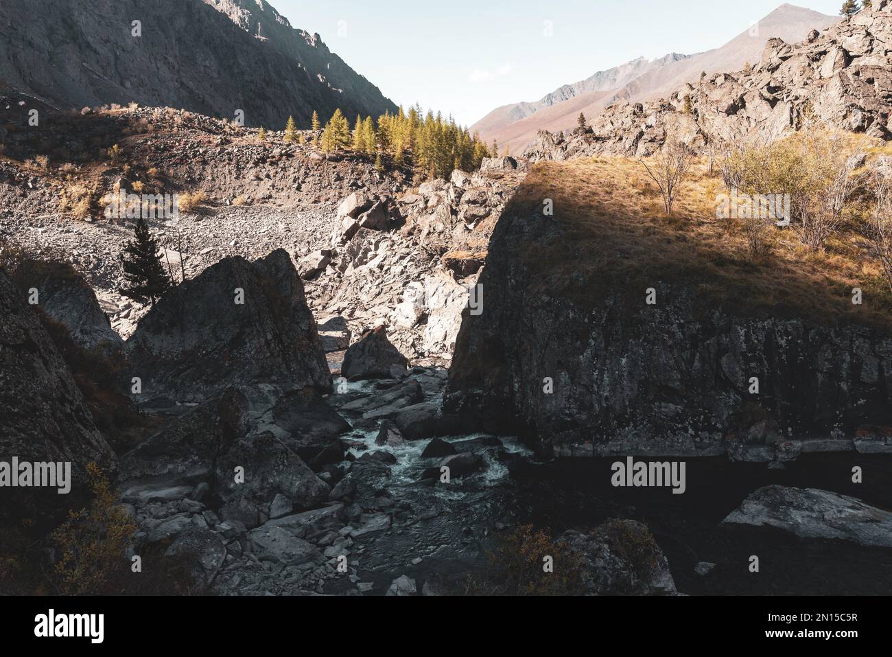 The Shavla River flows in the shade among large stones against the ...