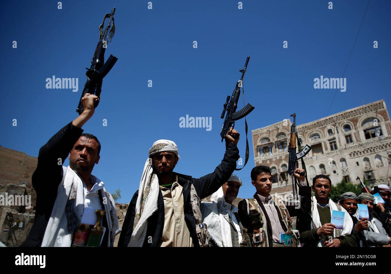 Shiite fighters, known as Houthis, hold up their weapons during a ...