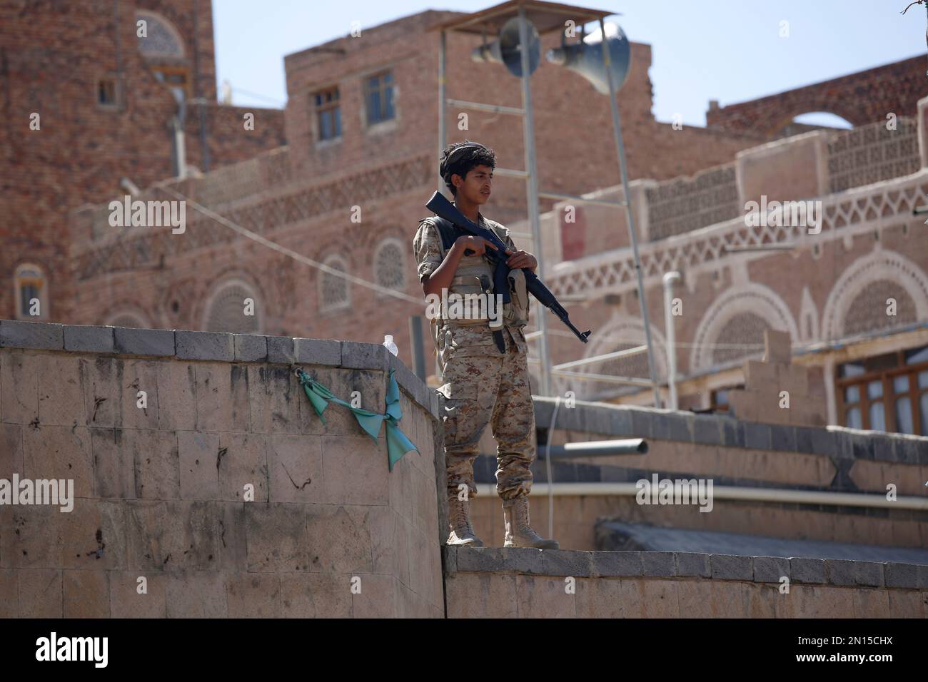 A Shiite fighter, known as a Houthi wearing army uniforms stands guard ...