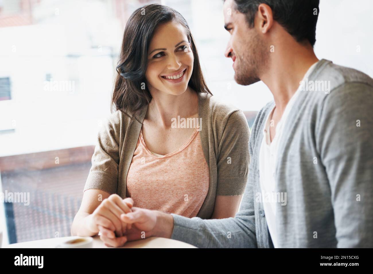 Looking deep into each others eyes. a young couple grabbing a cup of coffee together Stock Photo ...