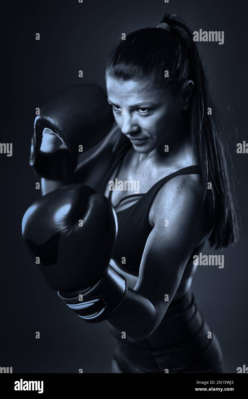 Woman boxer in boxing gloves, hitting with an uppercut, monochrome ...