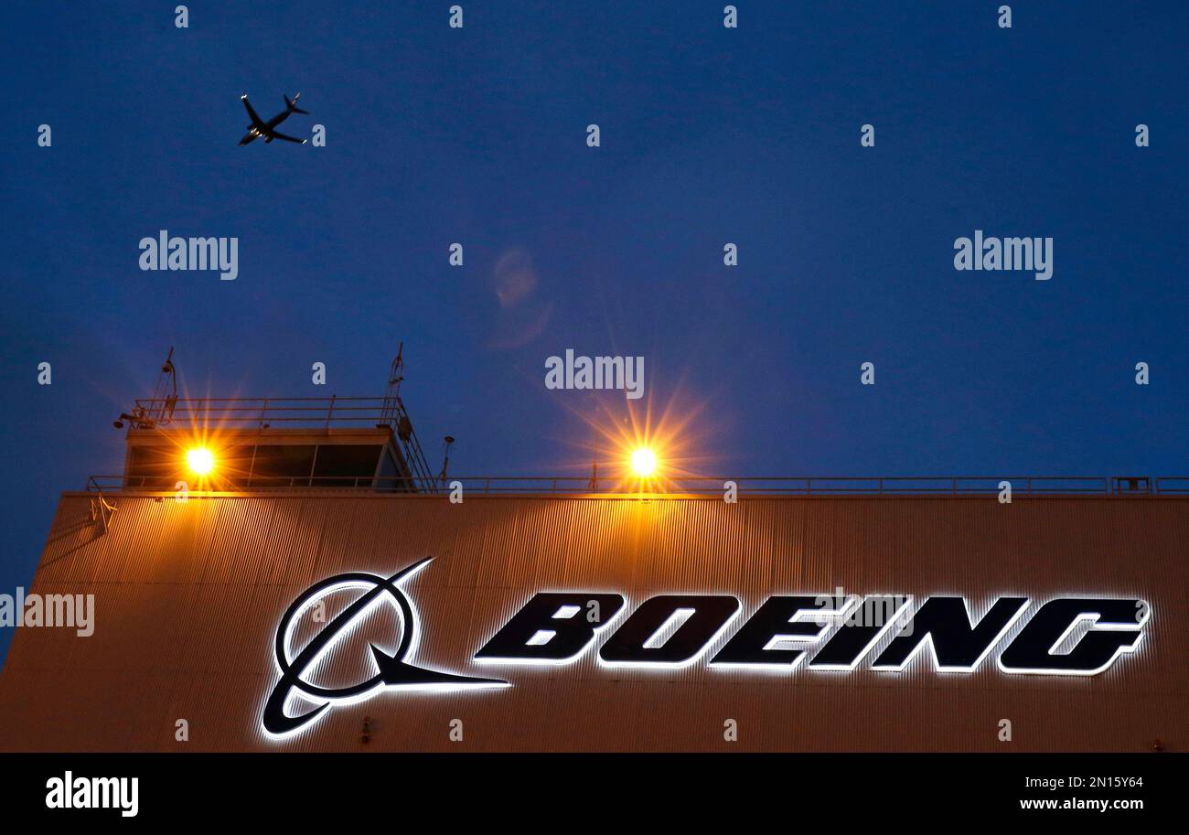 An airplane flies over a sign on Boeing's newly expanded 737 delivery ...