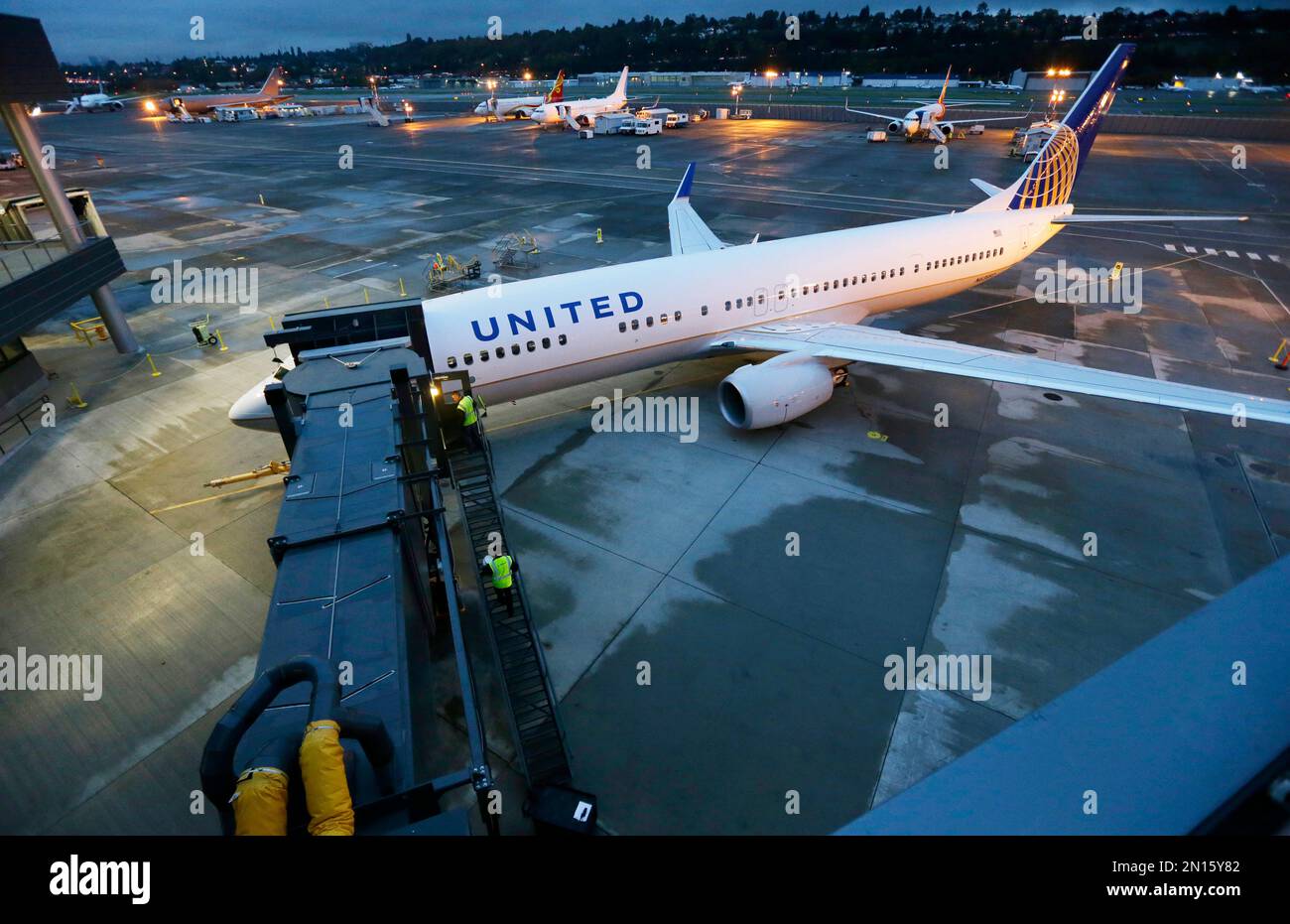 Workers walk up the steps of a jetway of a new Boeing 737-900ER ...