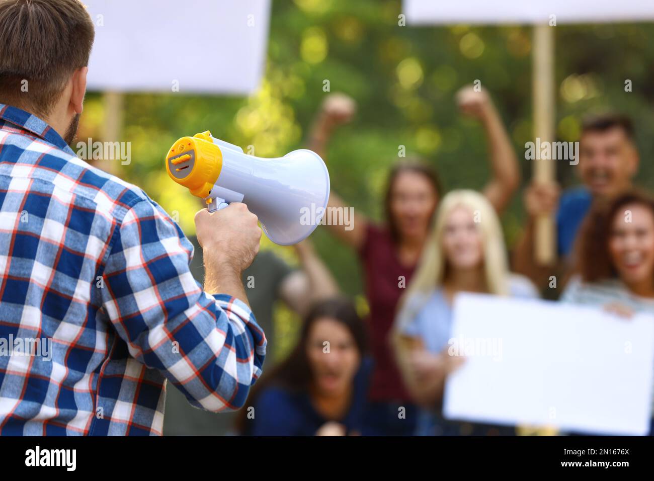 Protest leader with megaphone talking to crowd outdoors Stock Photo - Alamy