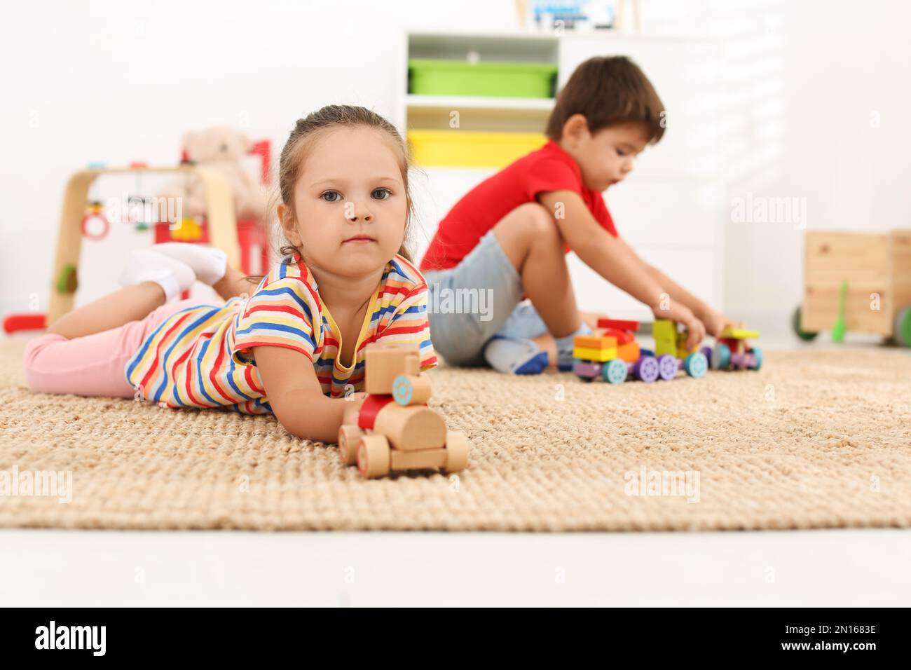 Cute little children playing with toys on floor at home Stock Photo - Alamy