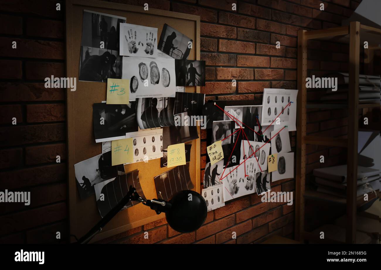 Boards with fingerprints, crime scene photos and red threads on brick ...