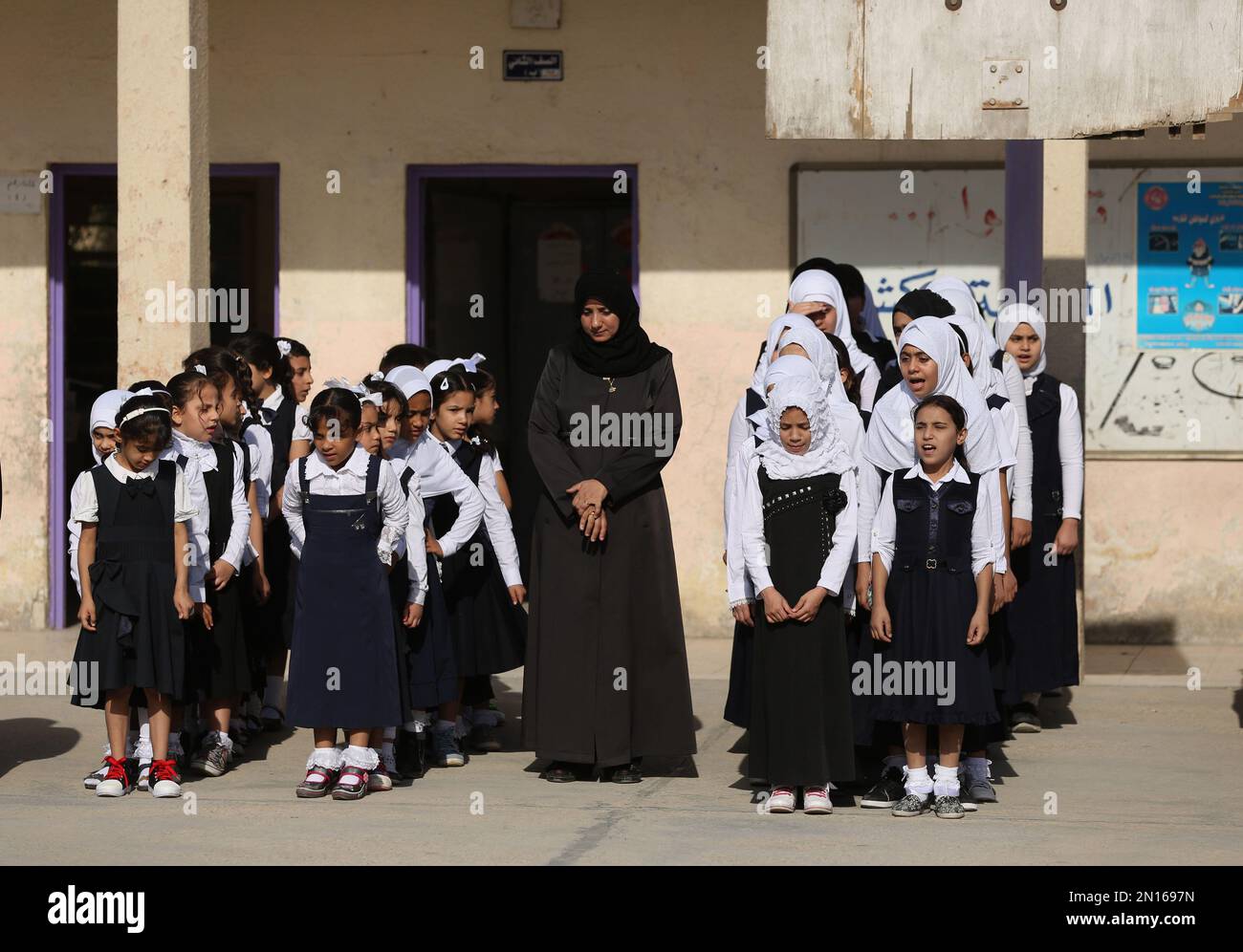 Iraqi students line up in their new uniforms on the first day of school ...
