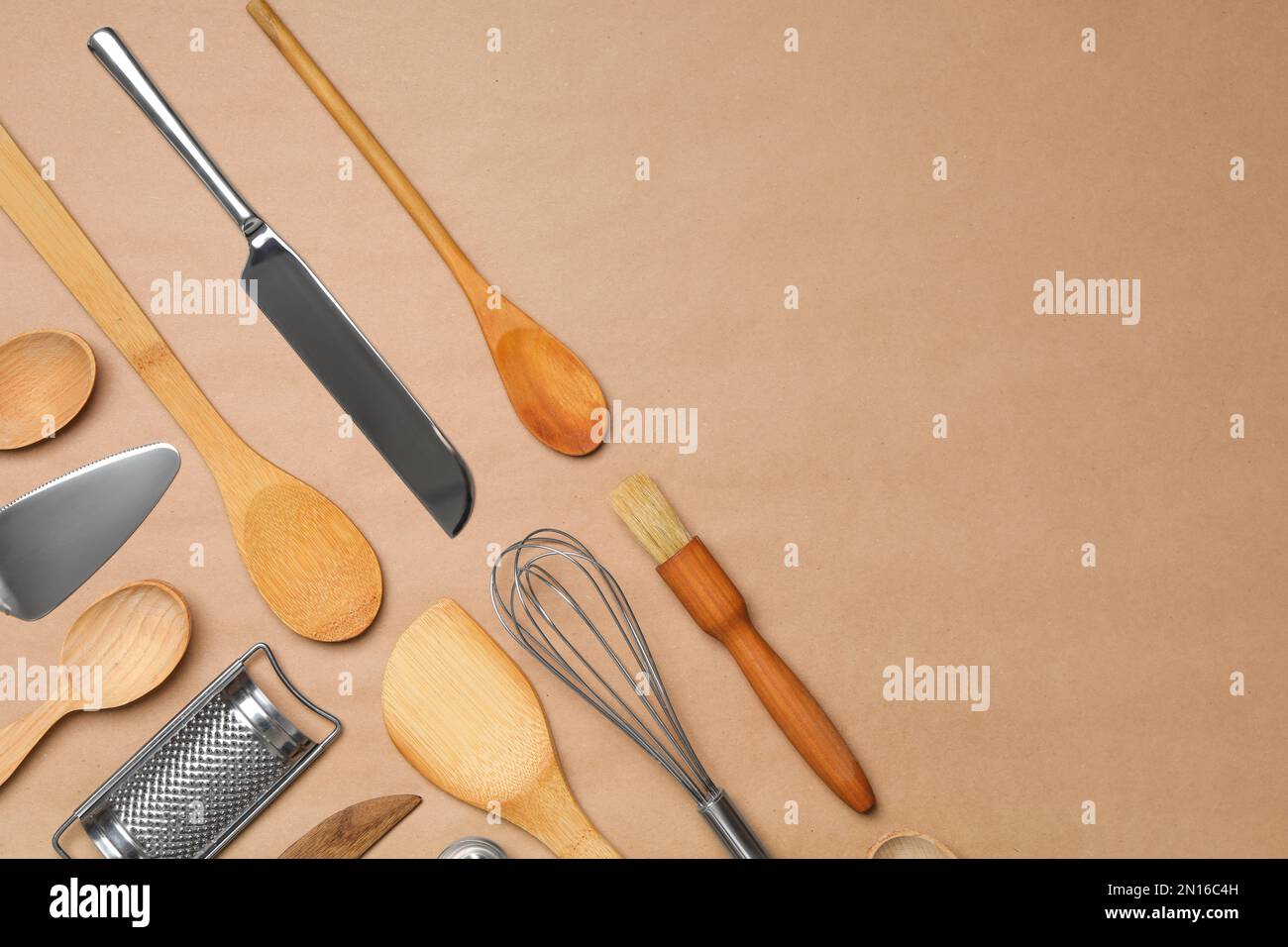 Set of modern cooking utensils on brown background, flat lay. Space for ...
