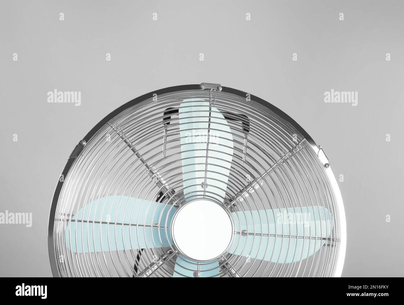 Electric fan on light grey background. Summer heat Stock Photo - Alamy