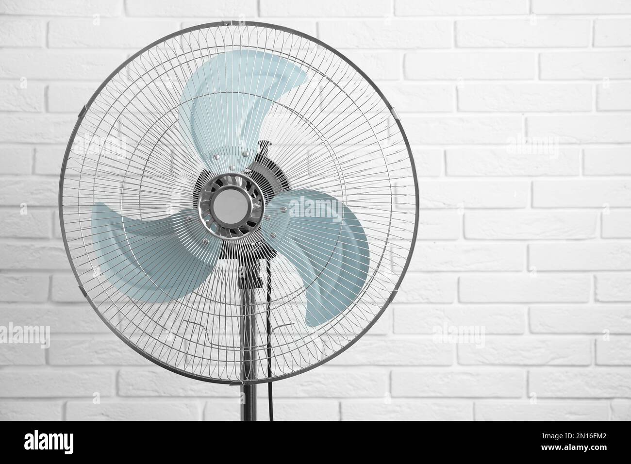 Electric fan near white brick wall. Summer heat Stock Photo - Alamy