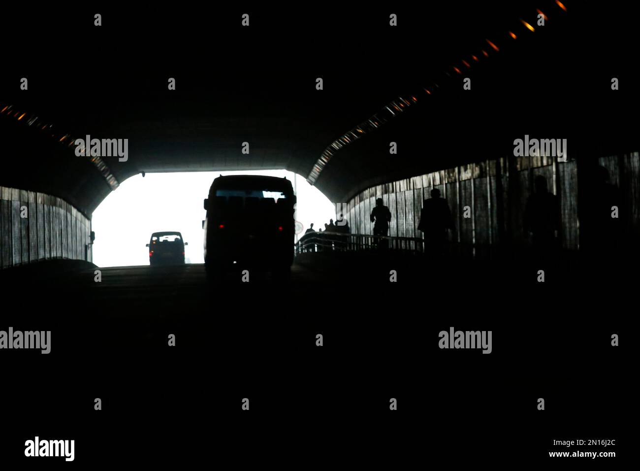 Motorists, pedestrians, and cyclists pass through a tunnel in Pyongyang ...
