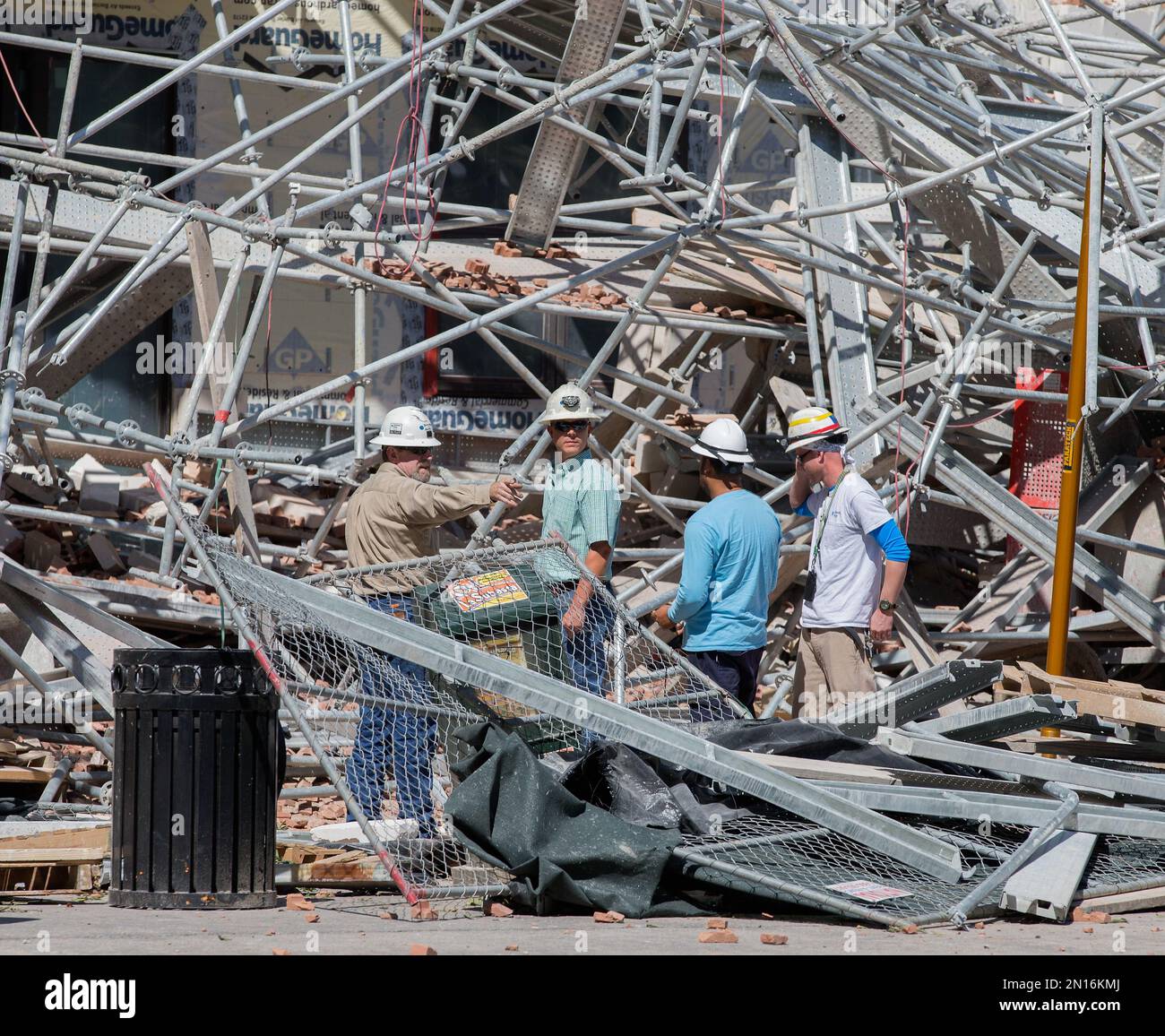 Workers from Center Point Energy look through the rubble after a ...