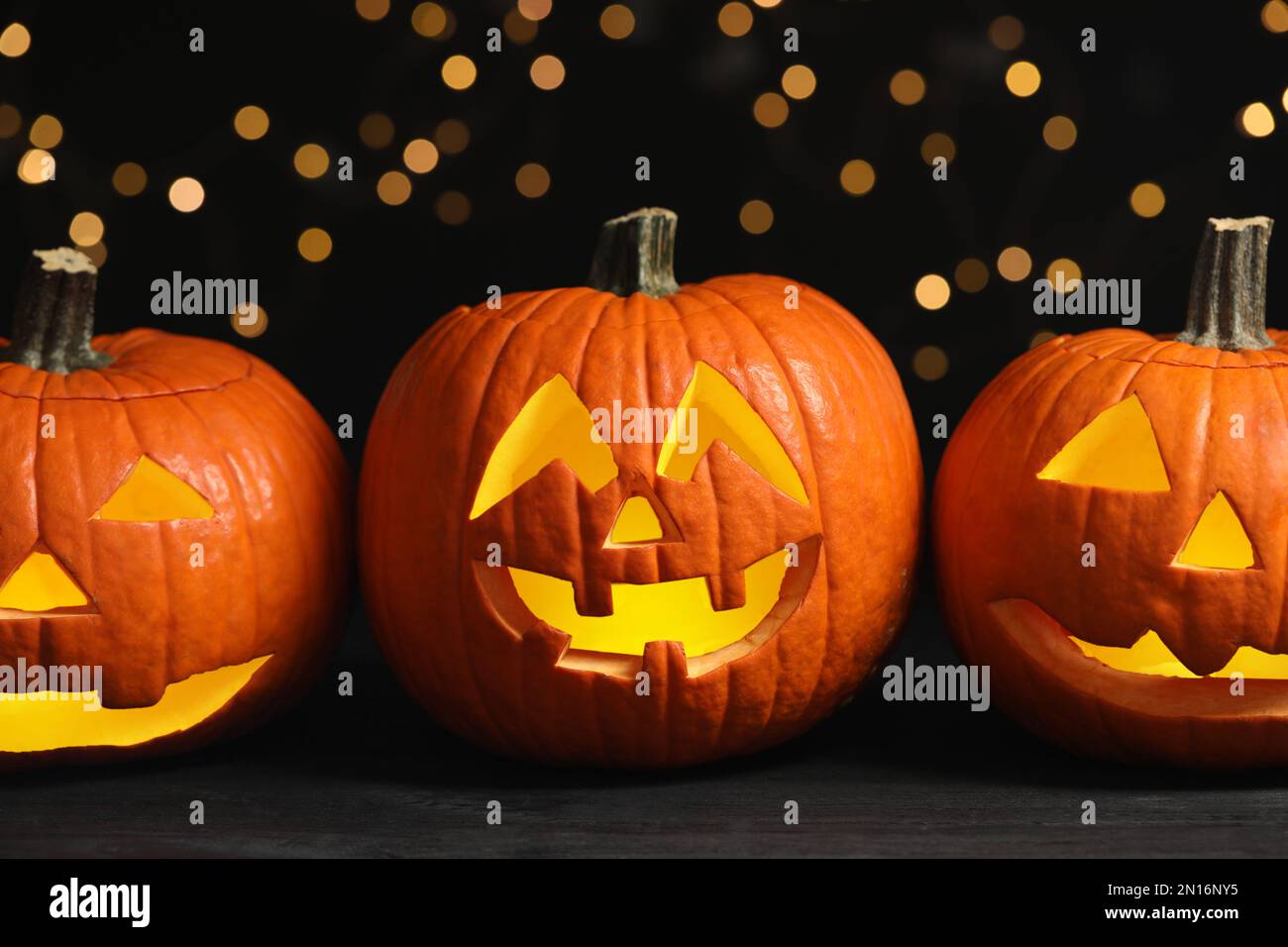 Pumpkin jack o'lanterns on table against blurred background. Halloween ...