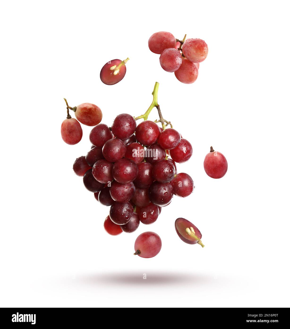 Fresh ripe grapes falling on white background Stock Photo - Alamy