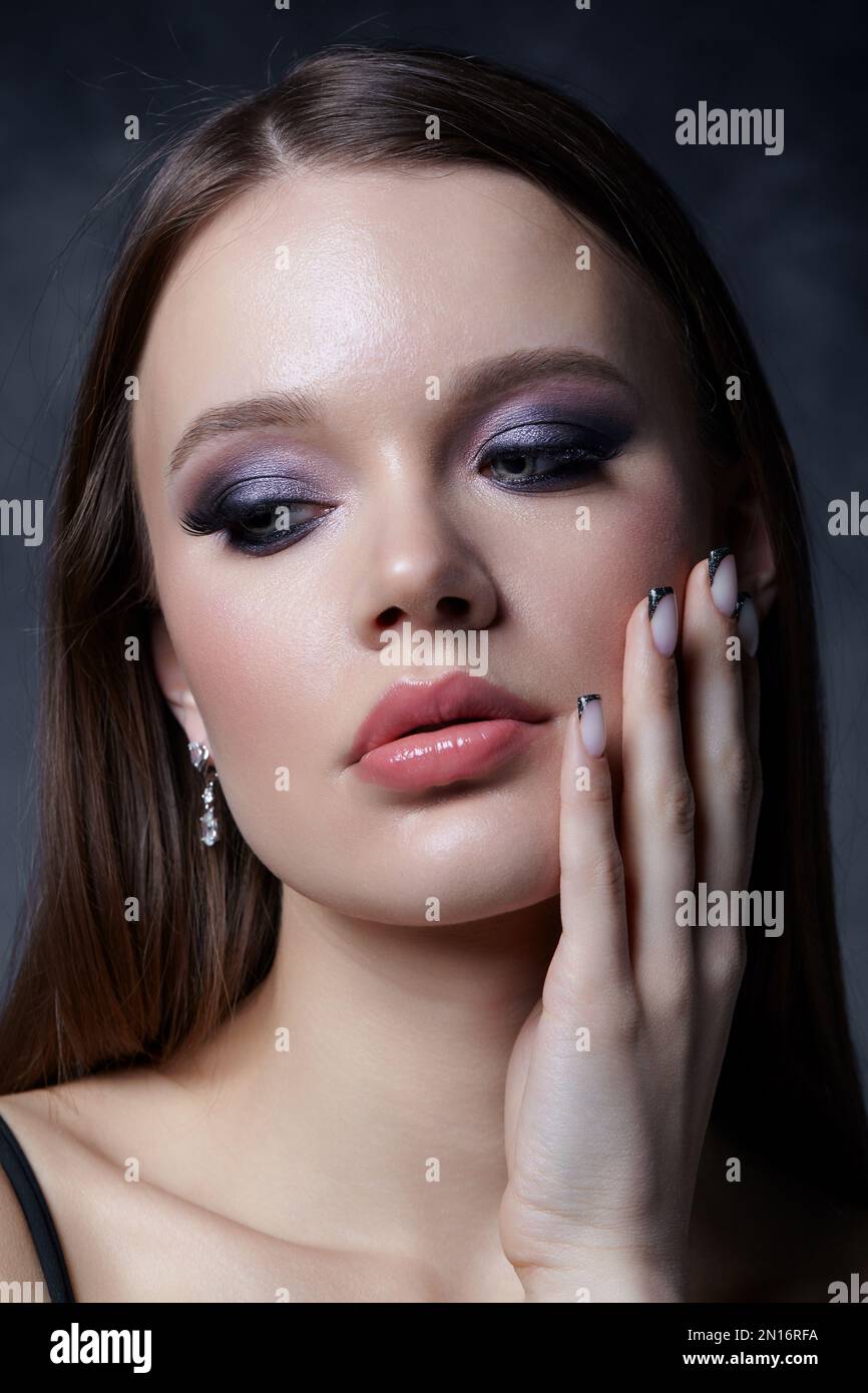Portrait of female face. Hand with black french manicure nailsnear face ...