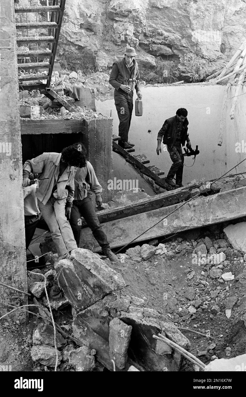Palestinian guerrillas search the rubble of their destroyed base near ...