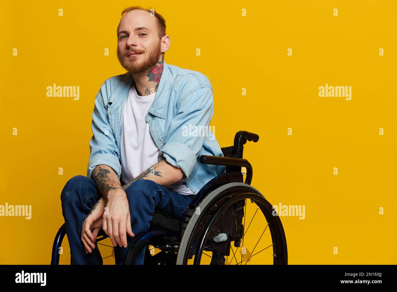 A man in a wheelchair smile and happiness, thumb up, with tattoos on ...