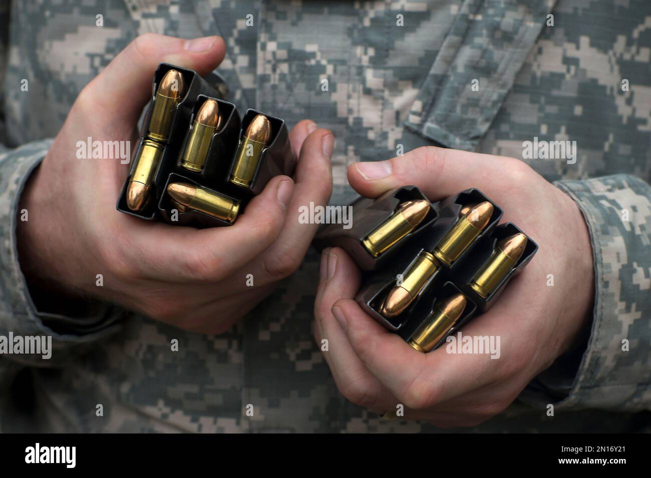 A members of the 139th Military Police Company holds ten clips of 9mm ...