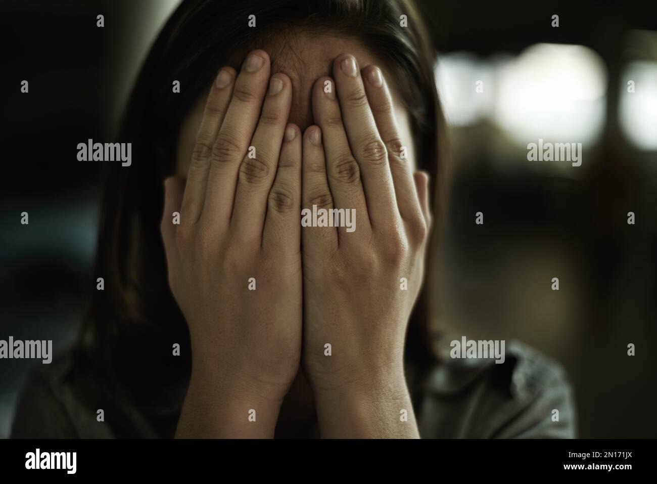 Im so afraid...A young woman looking anxious and fearful with her hands ...