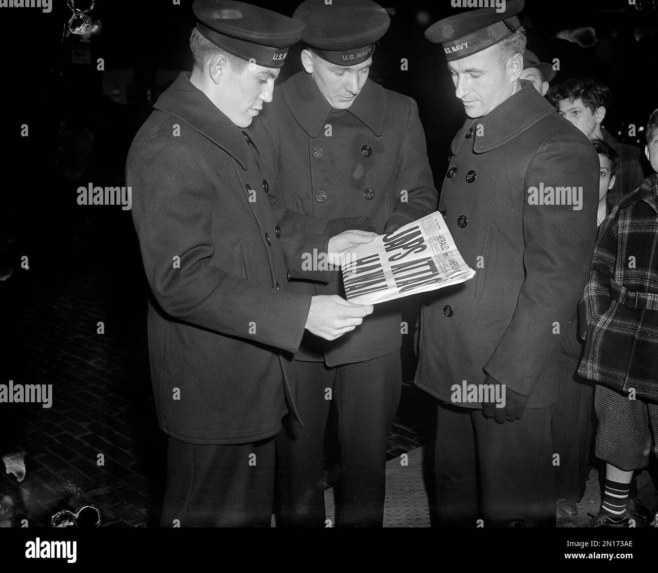 Three sailors stationed at the Navy pier in Chicago view a newspaper ...