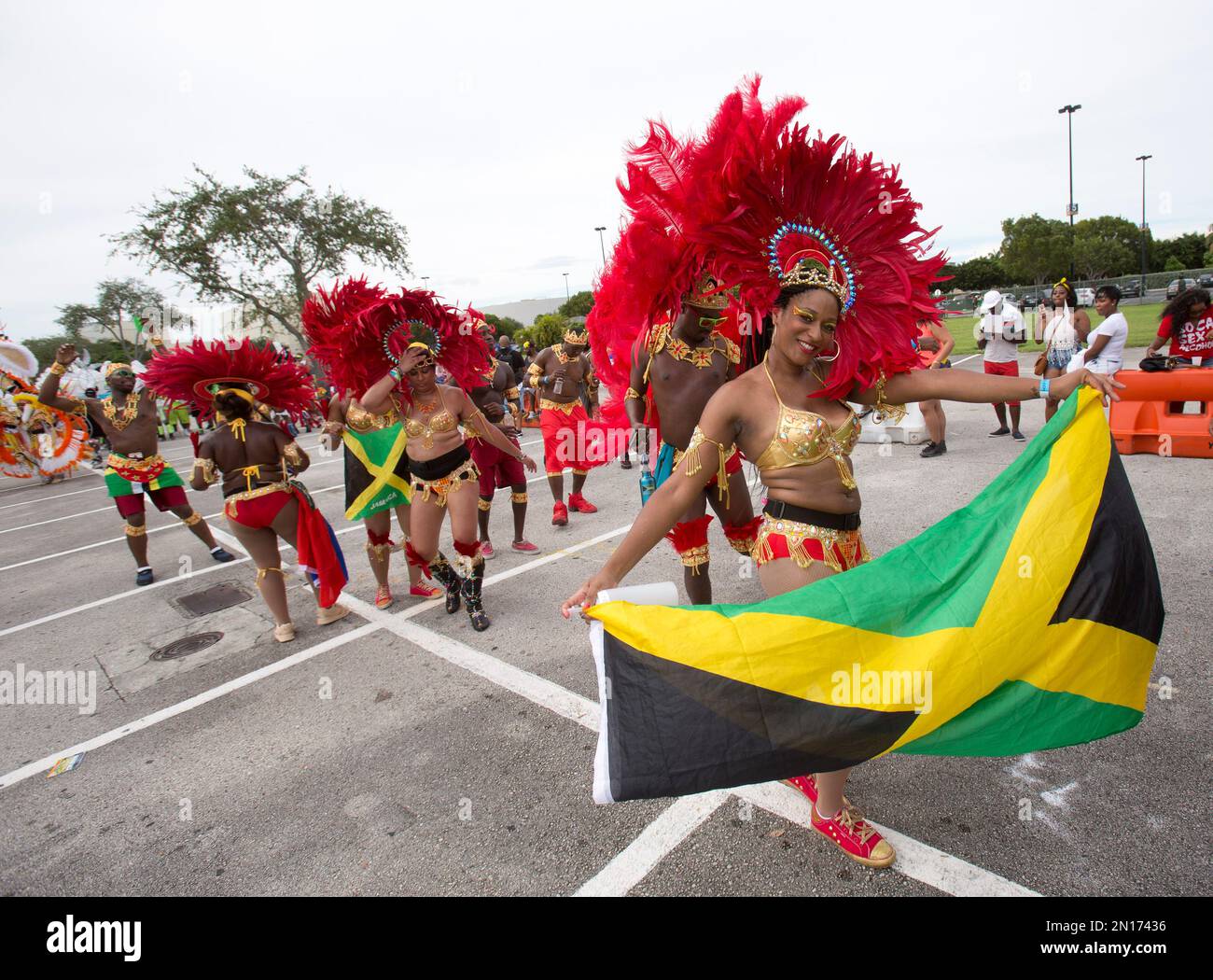 A dancer holds up a Jamaican flag as she marches during a parade of ...