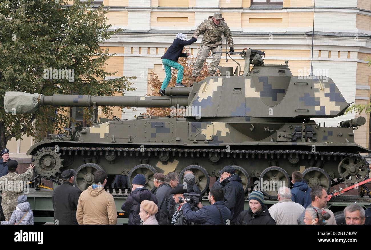 A Ukrainian soldier helps a boy climb onto a tank during the opening of ...