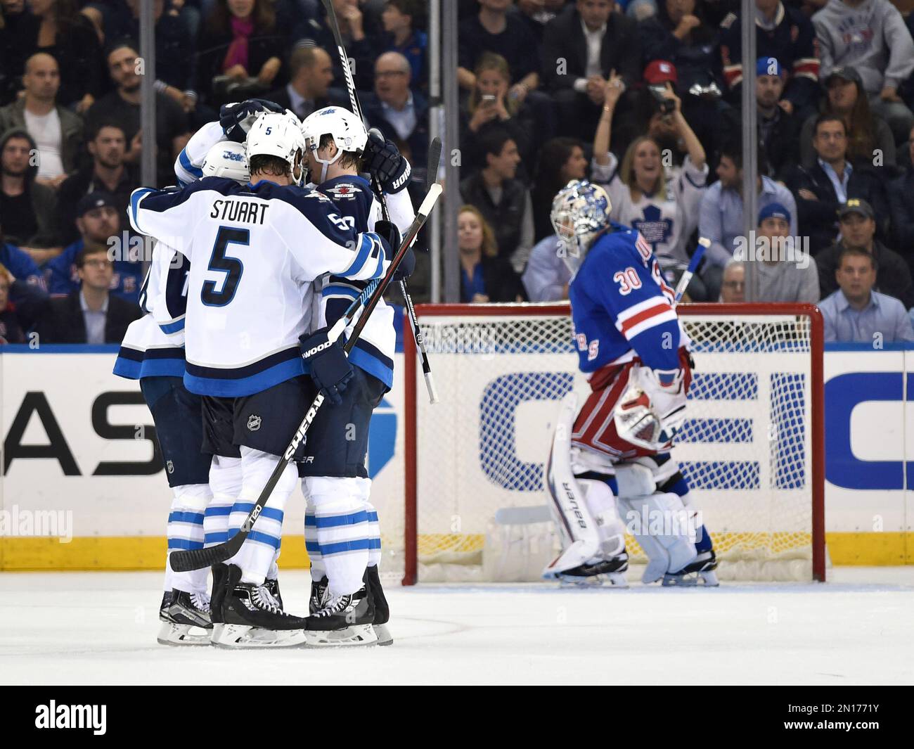 Winnipeg Jets defenseman Mark Stuart (5) and teammates gather around ...