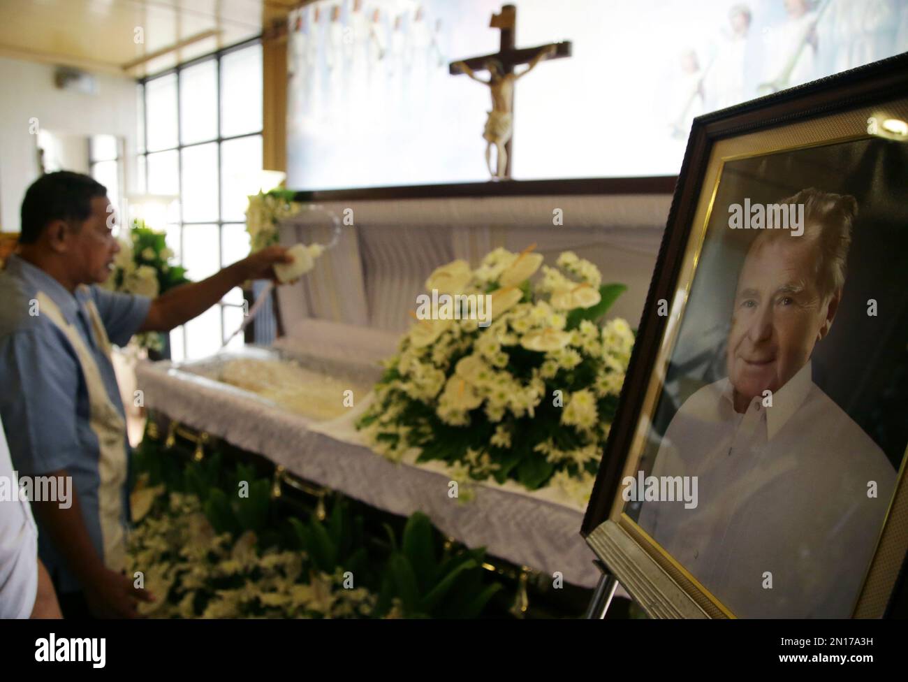 Alvino Nardo sprinkles holy water on the casket of his brother-in-law ...