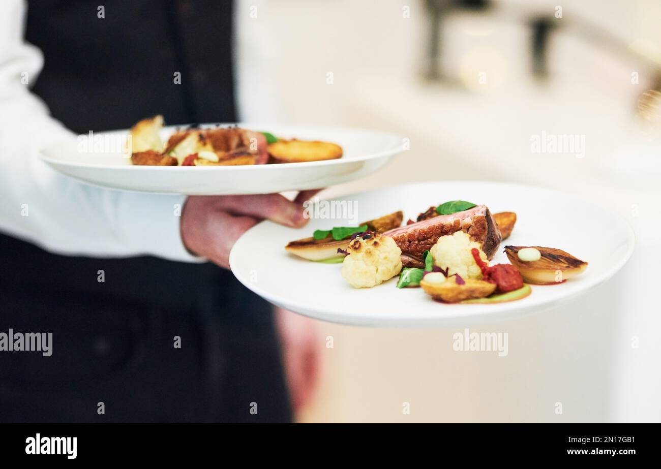 Restaurant, plates and waiter serving food for fine dining, luxury meal ...