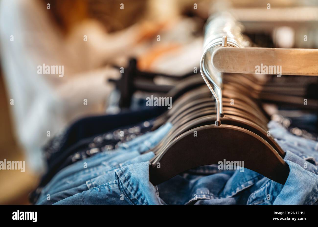 Group of clothes hanging on hangers in a store. Shopping retail concept ...