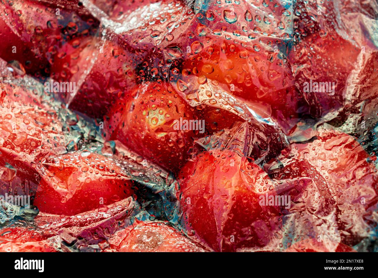 Textured background of freshly picked tomatoes under glass or film with ...
