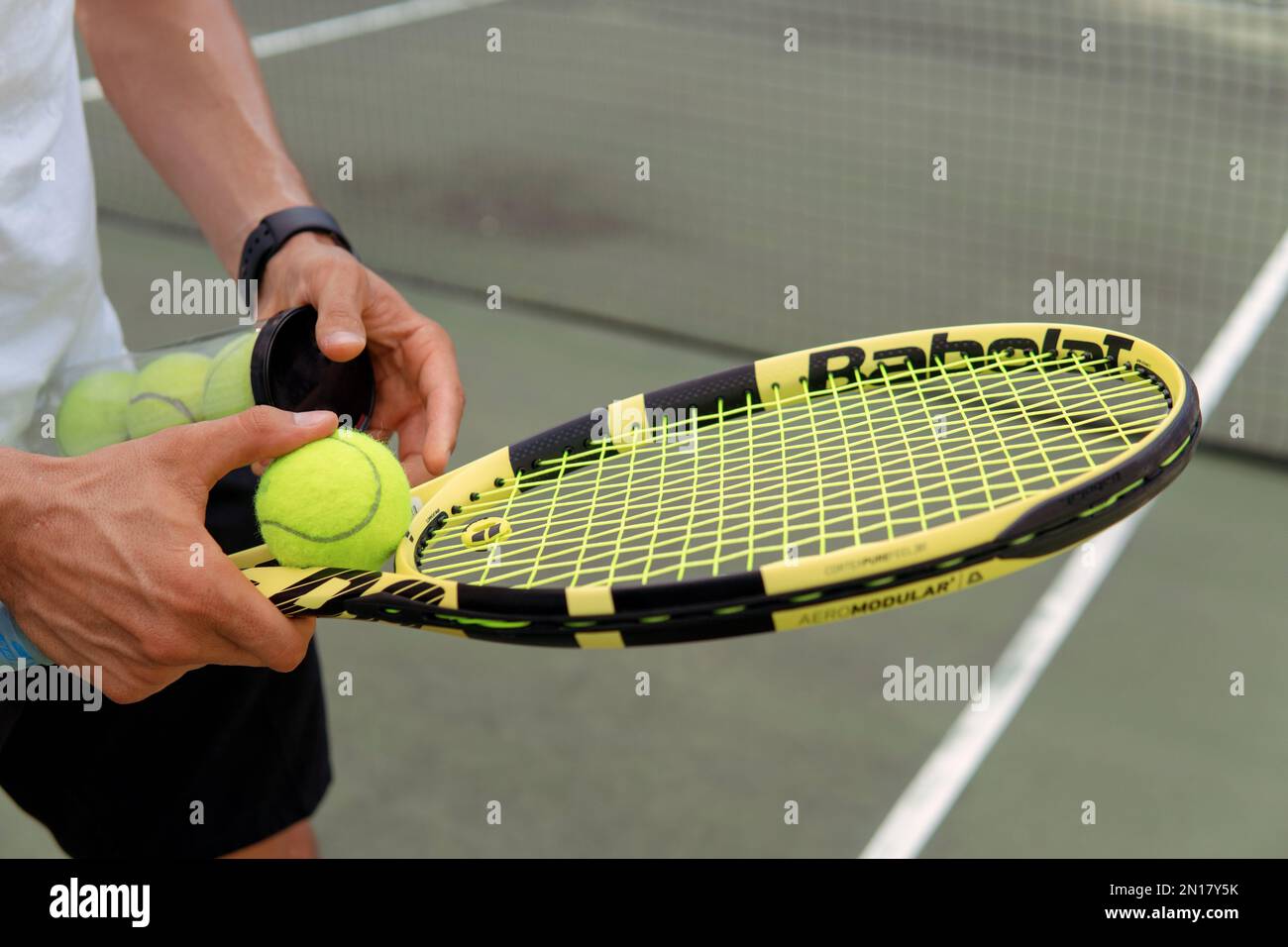 close-up. male hands holding tennis racket and balls. bali Stock Photo ...