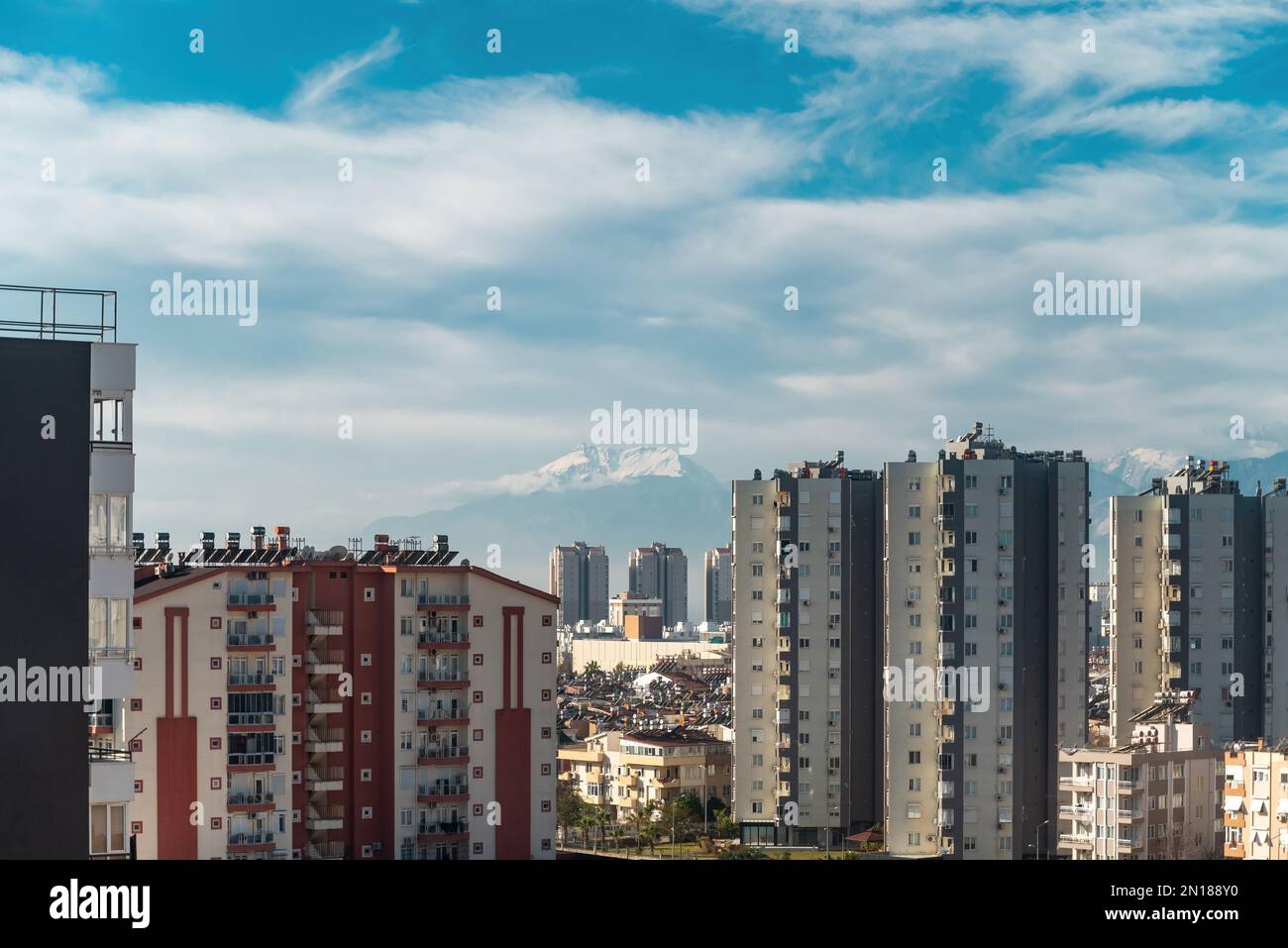 Snowy mountain peak visible through city buildings on a sunny day Stock ...