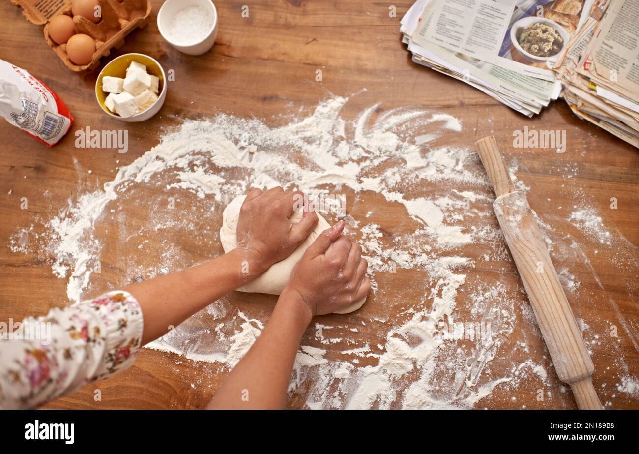 Making her famous bread recipe. Cropped view of hands working with fresh dough on a kitchen ...